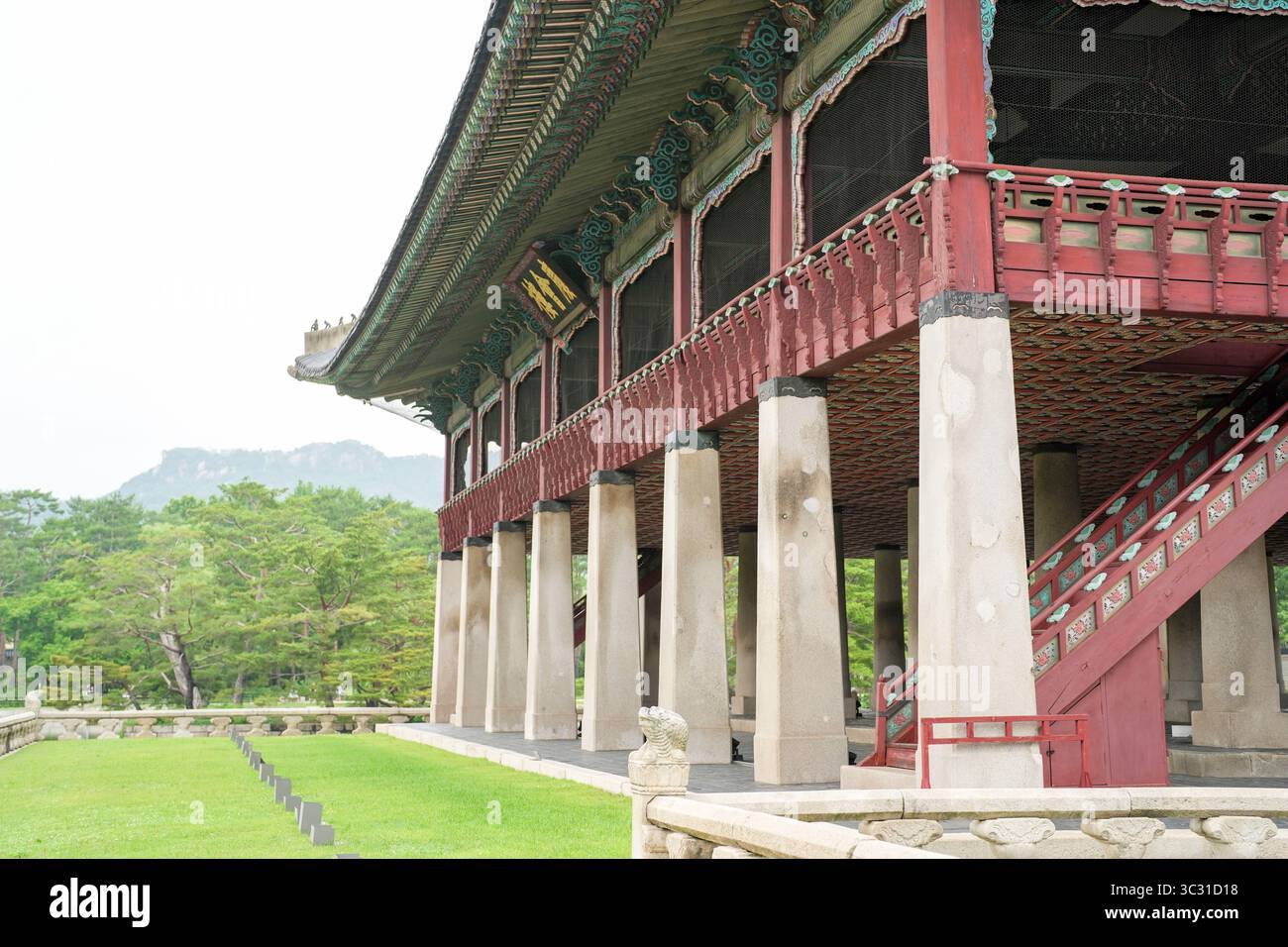 The historic structures of Gyeongbokgung Palace stand majestically under a summer sky, their ...