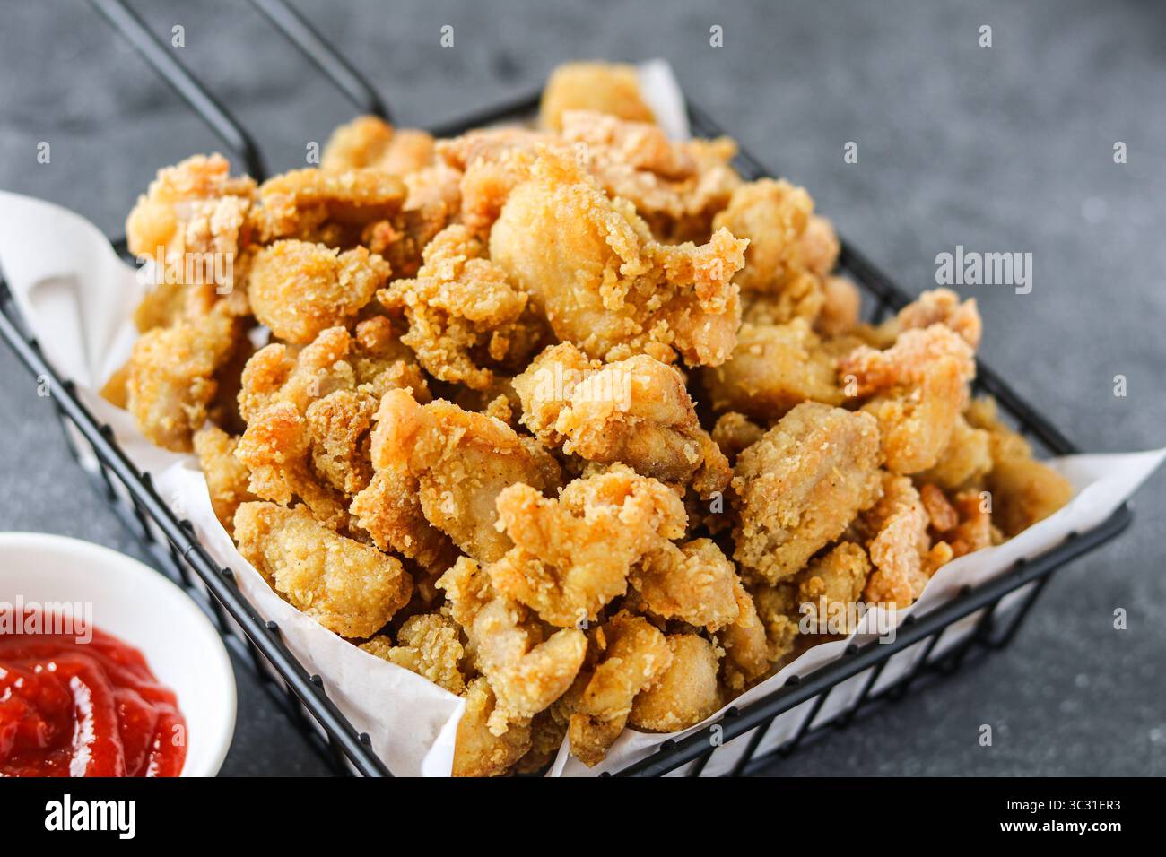 Golden-brown popcorn chicken or bite-sized fried chicken pieces, piled ...