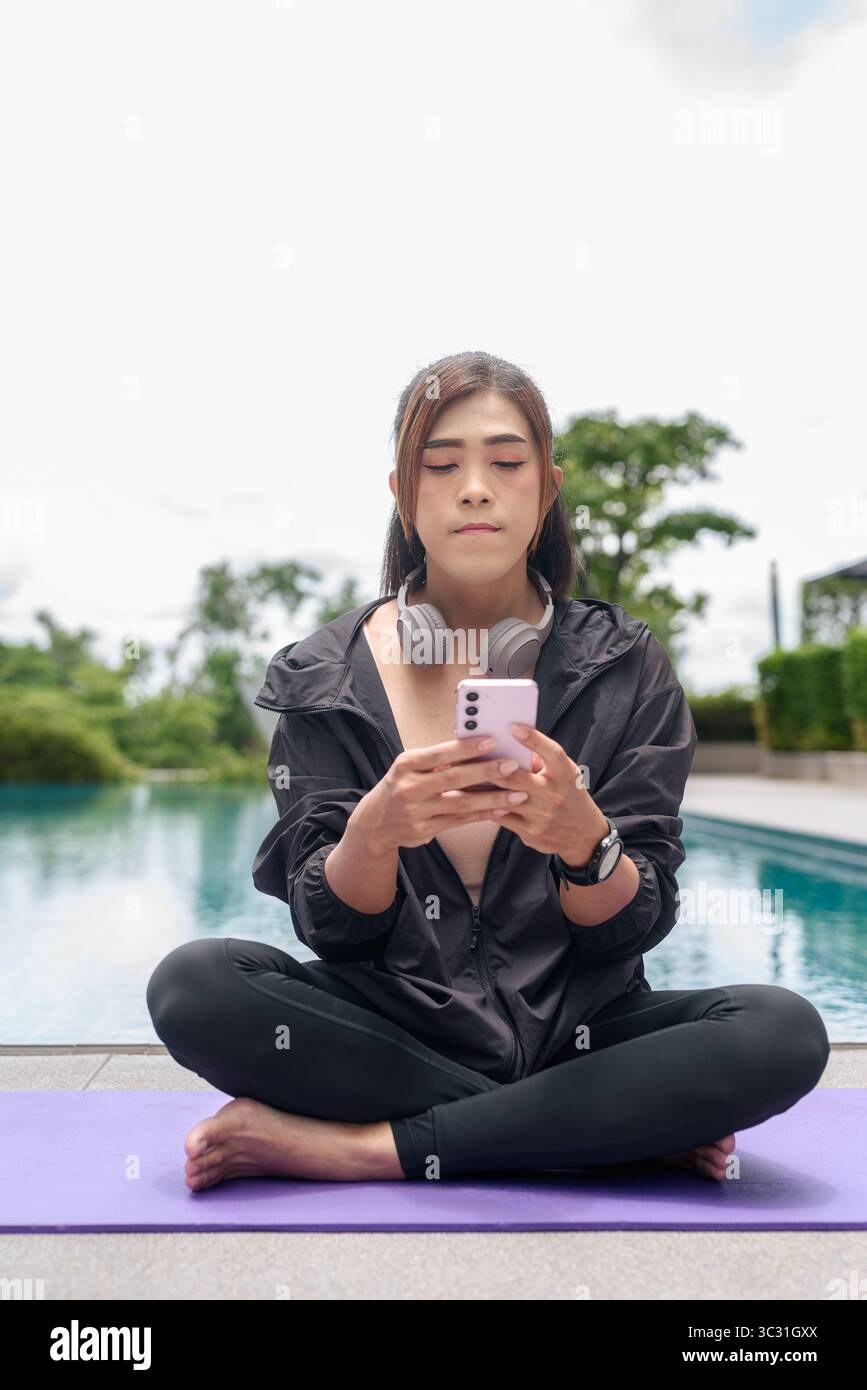 Transgender woman performing yoga poses outdoors by pool, showcasing ...