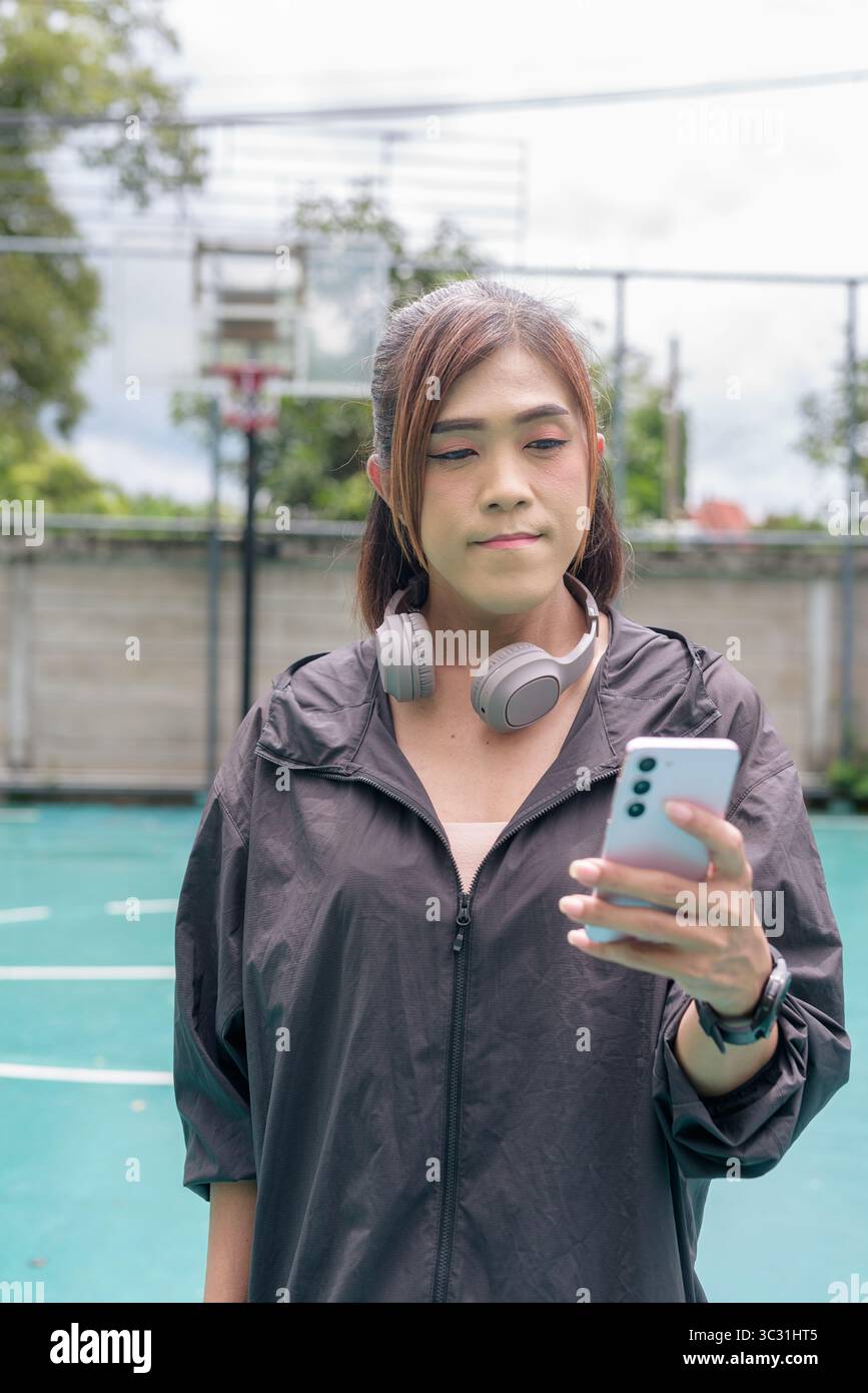 Portrait of a fit transgender woman standing on outdoor basketball ...