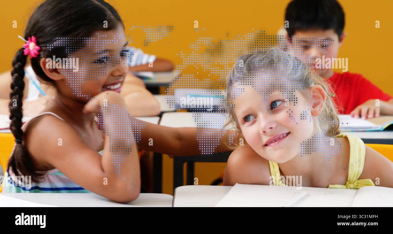 Smiling two girls leaning together and conversing in school classroom ...