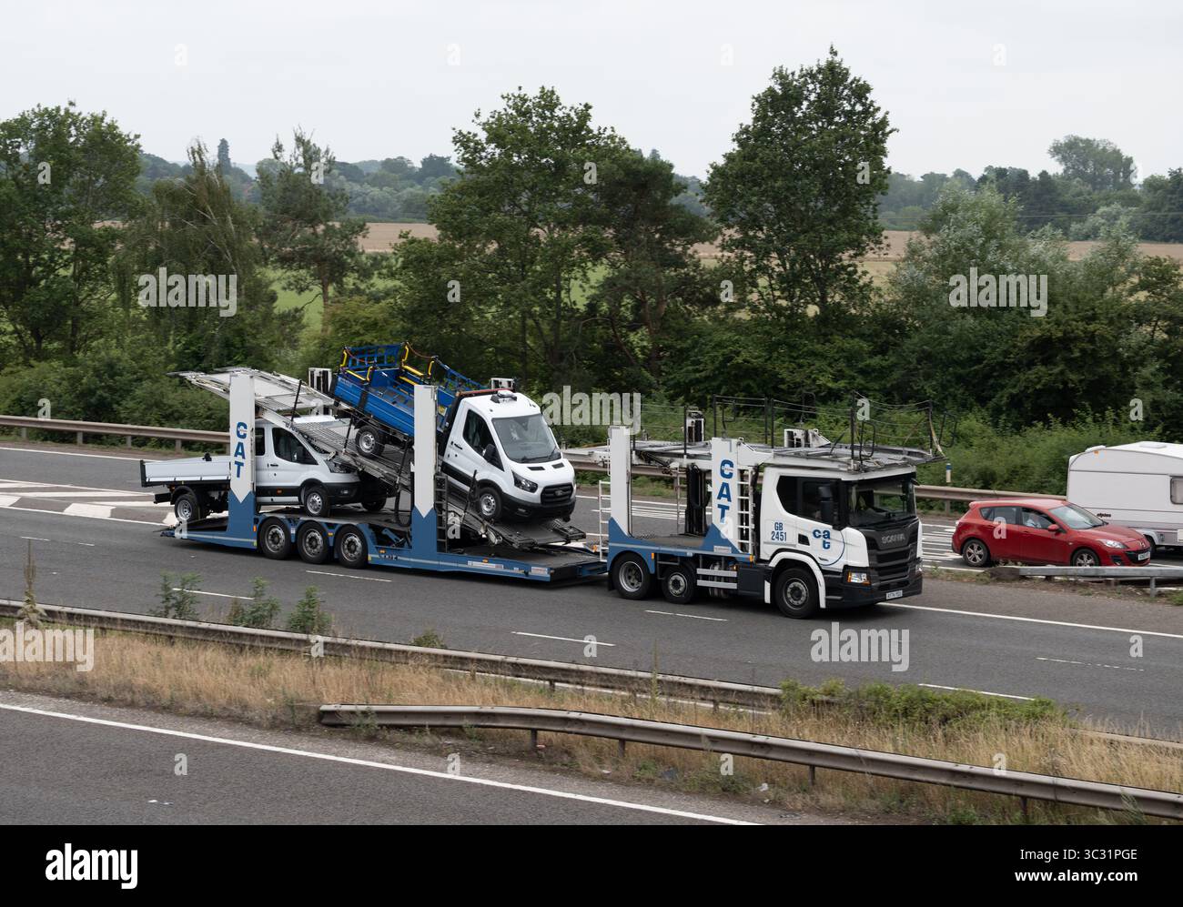 CAT transporter carrying new Ford pick-up trucks on the M40 motorway ...