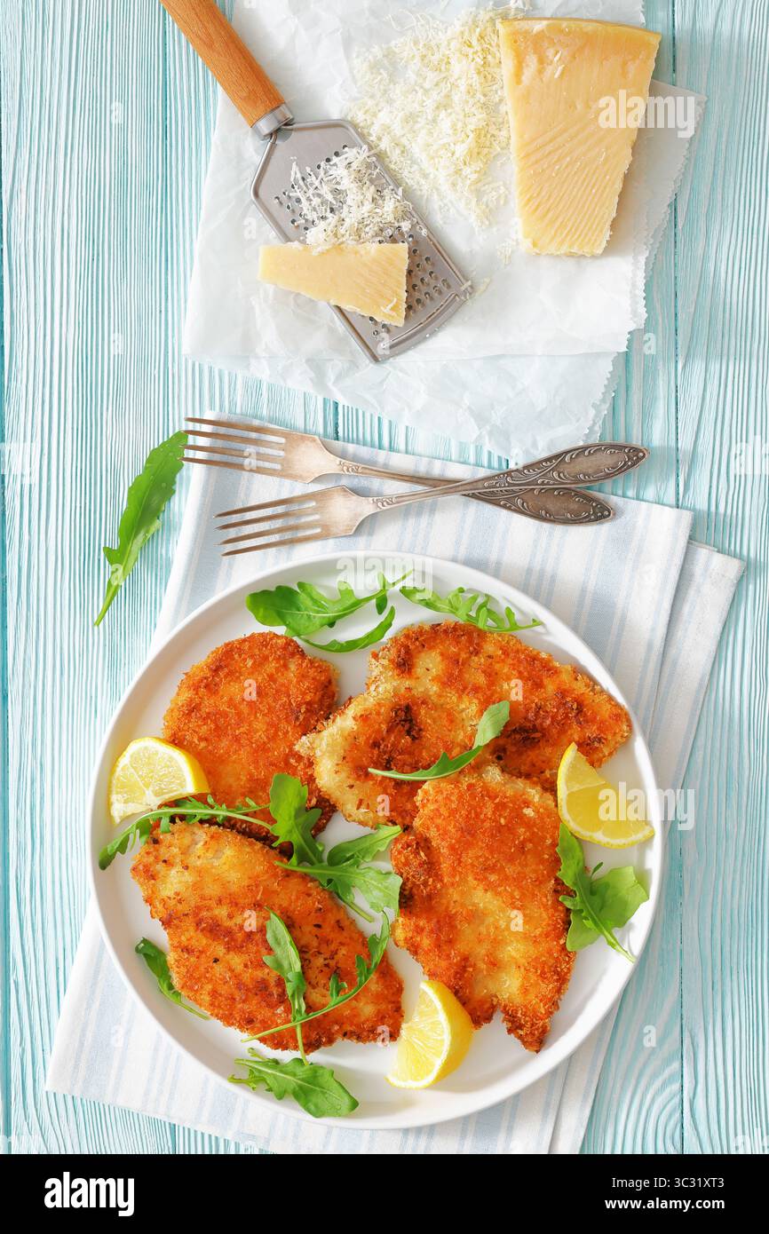 crispy parmesan crusted chicken cutlets on a plate with fresh rocket ...