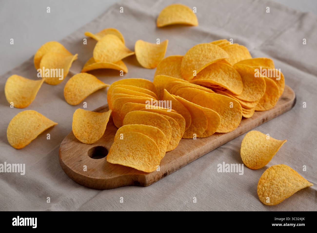 Bacon flavoured potato chips on a wooden board, side view Stock Photo ...