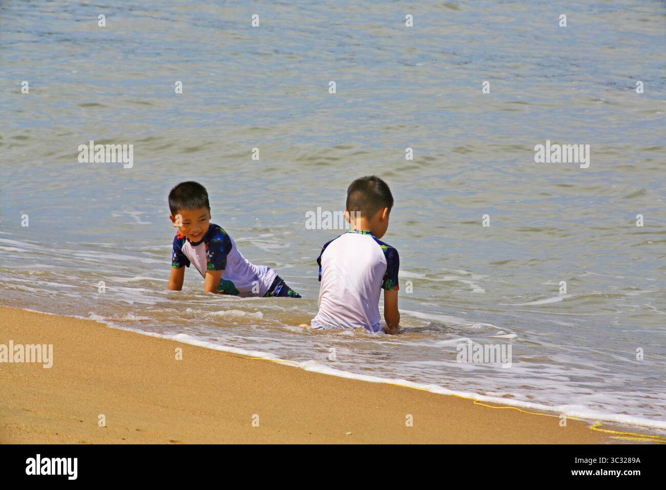 Tourists play at the seaside in Sanya City, southernmost China's Hainan ...