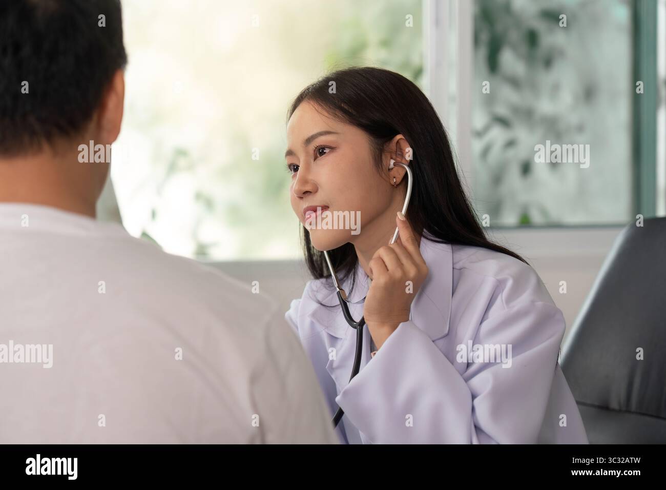 Patient Assessment. Female doctor using stethoscope to examine patient ...