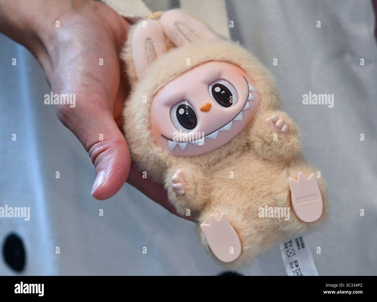 25 July 2025, Berlin: A woman holds a Labubu plush figure at the ...