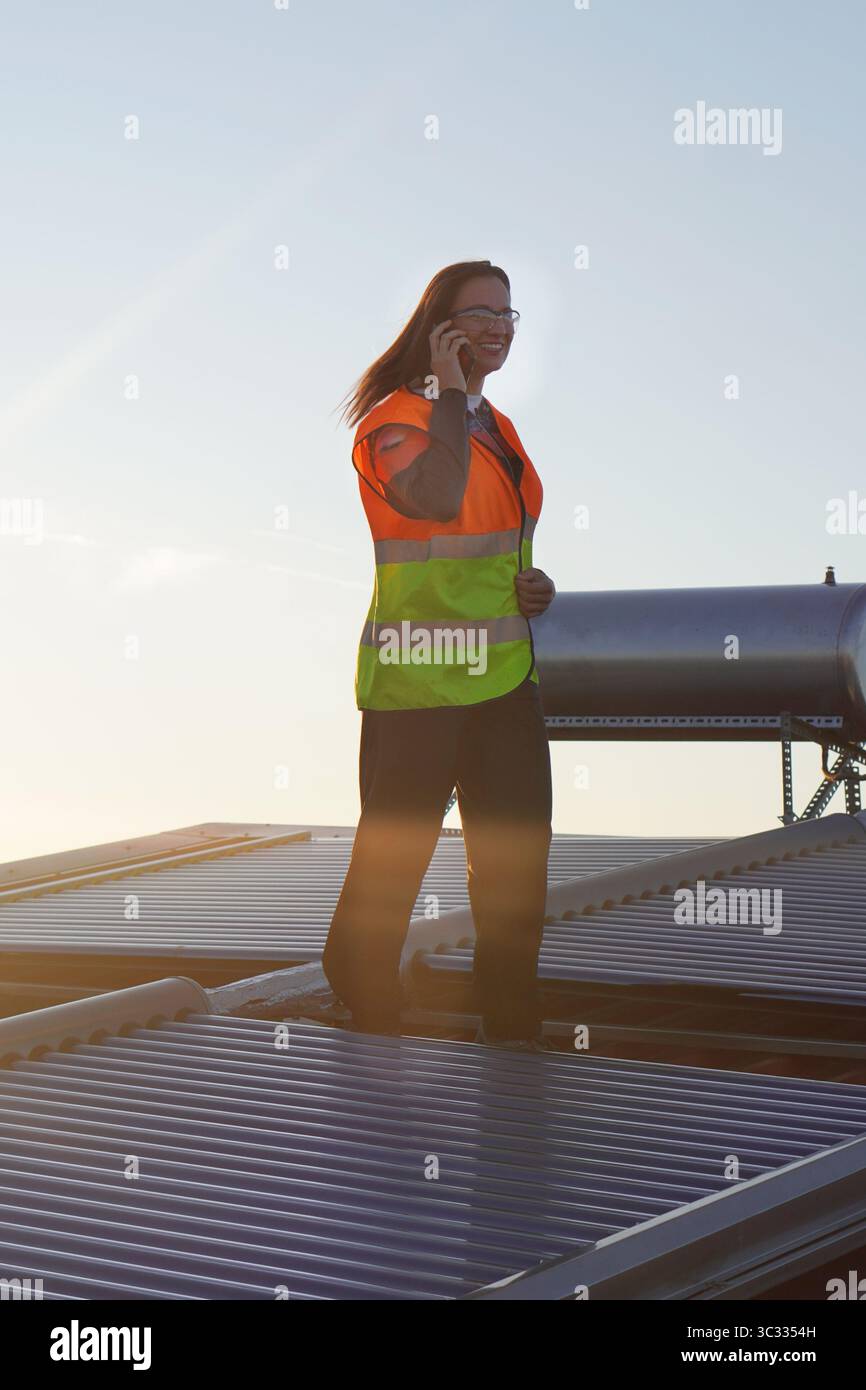 renewable energies. female solar panel installer technician checking an ...