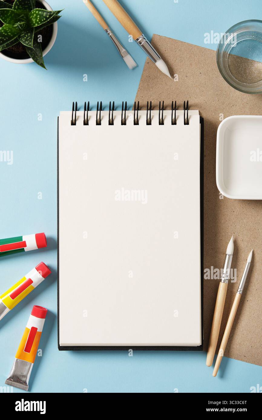 Creative preparation. An open album with a blank page, paints, and ...