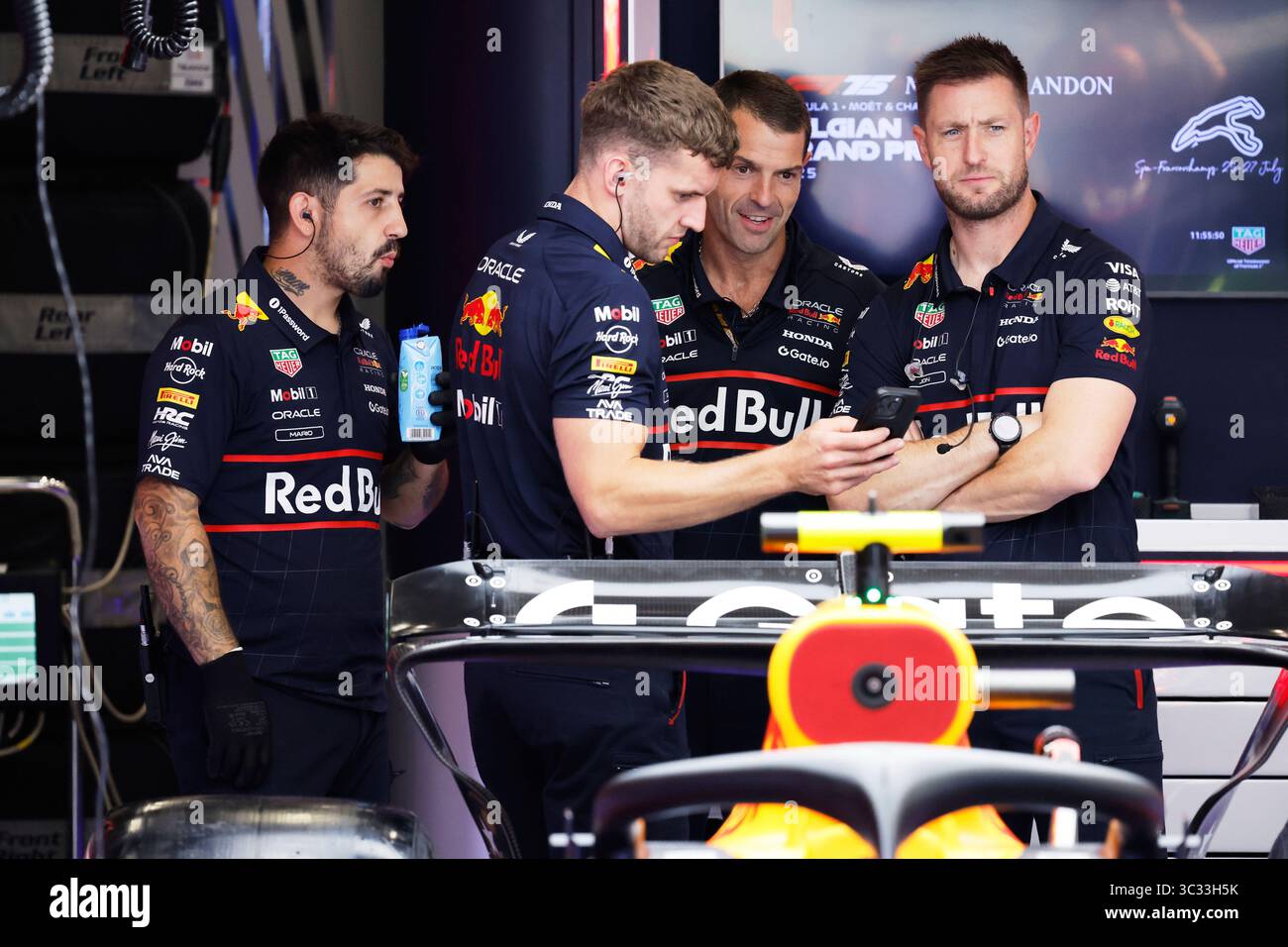 Red Bull crew work in the team garage prior to the first practice ...