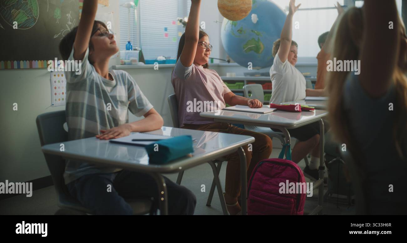 Elementary School Students Sitting at the Desks, Listening to Lecture ...