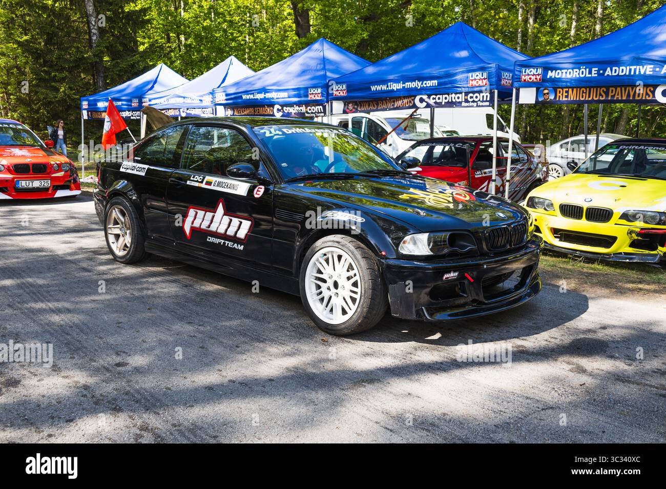 Black BMW drift car with sponsor livery in sunny paddock. Alytus ...