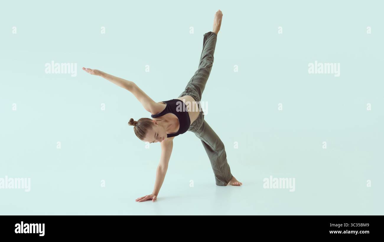 Female dancer holding one-arm floor balance with extended leg and ...