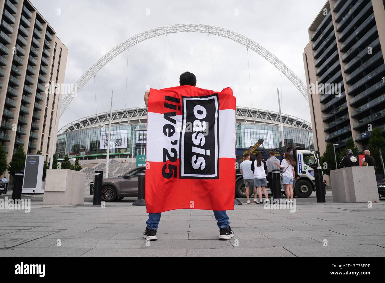 An Oasis fans holds a flag outside the stadium, ahead of the first ...