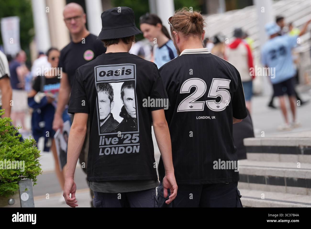 Fans wearing Oasis merchandise are seen outside the stadium ahead of ...