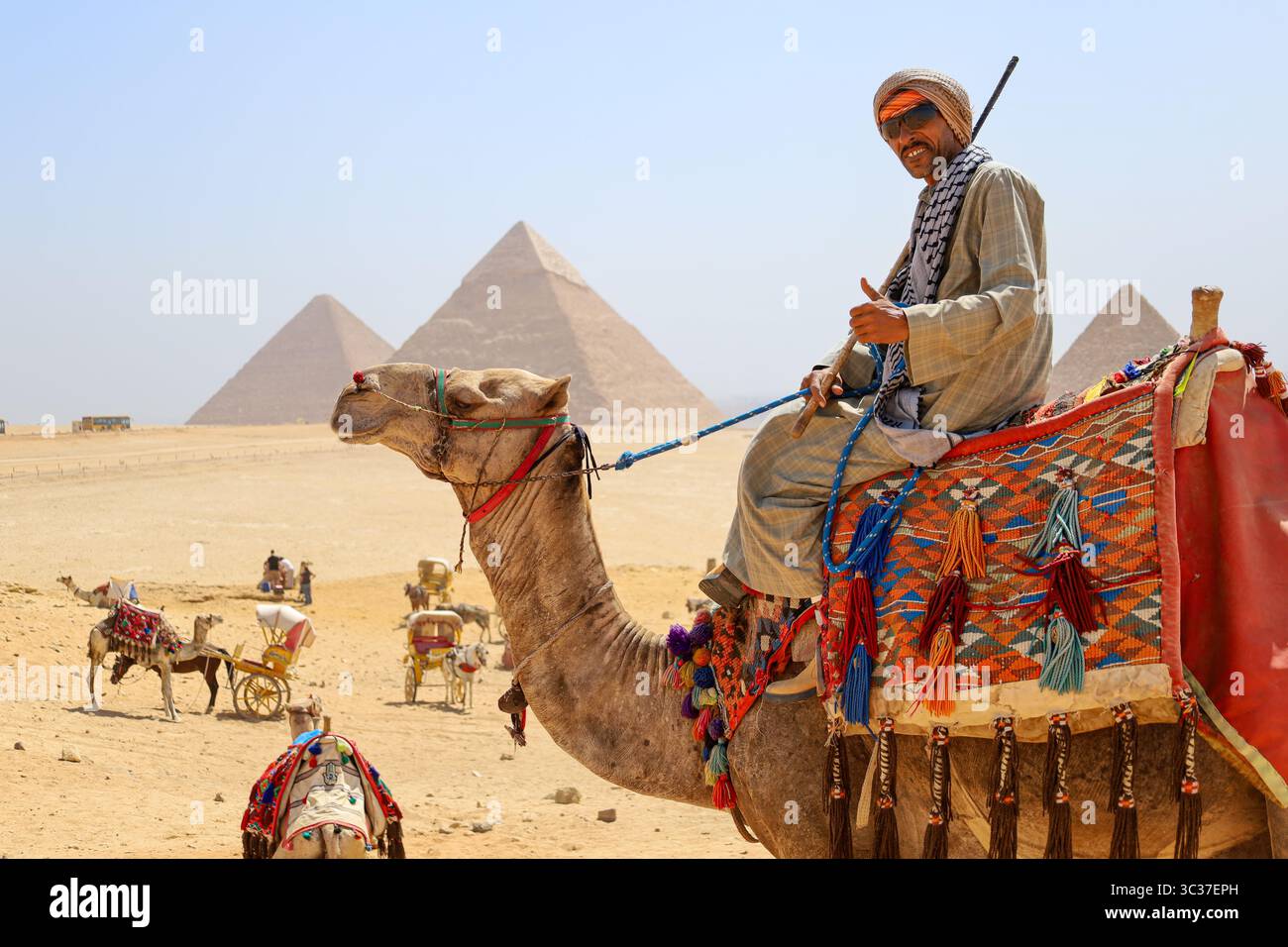 Giza, Egypt, July 17, 2025: a tourist riding a camel in front of ...