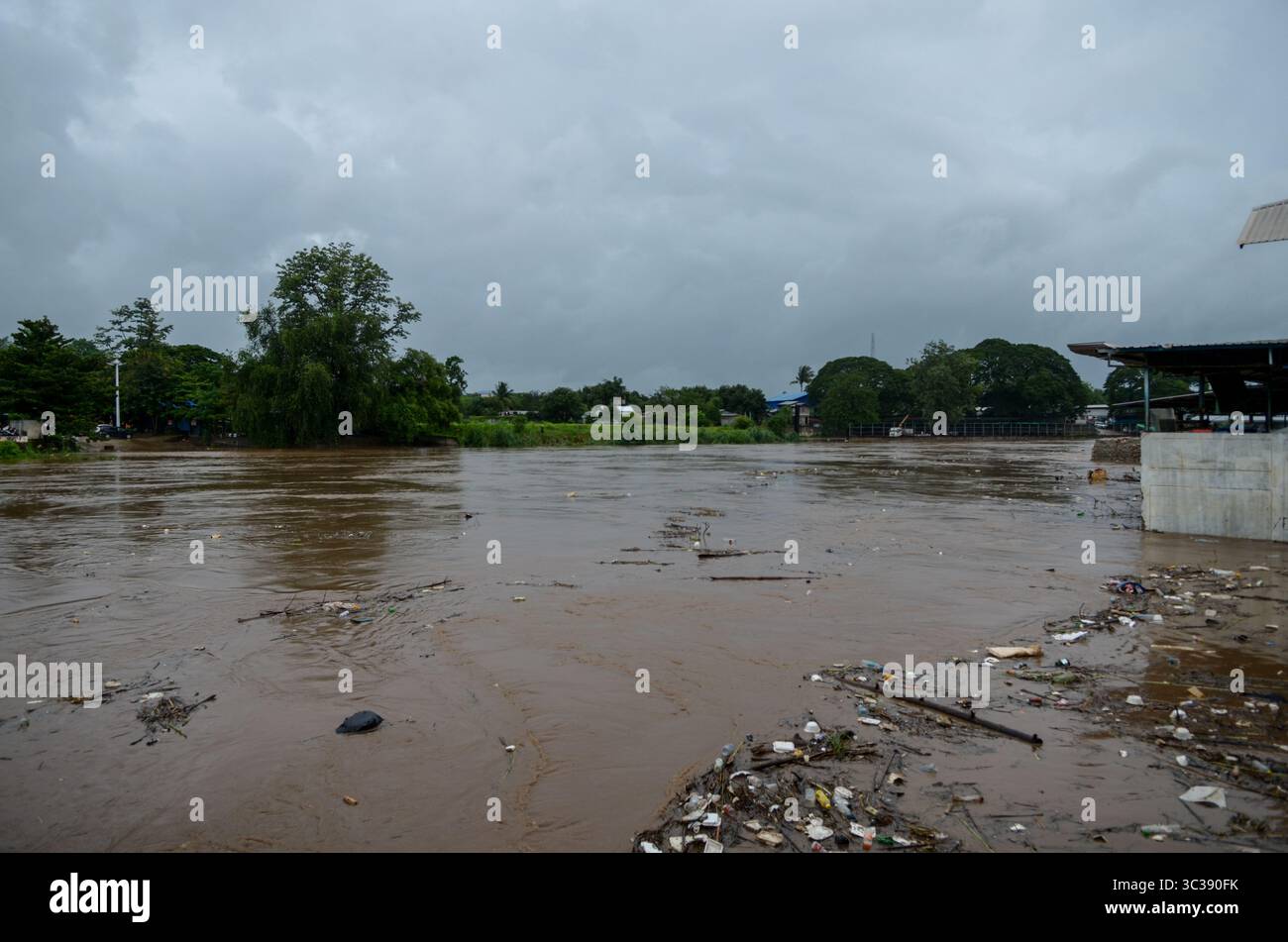 The swollen Moei River overflows its banks in Mae Sot, its muddy ...