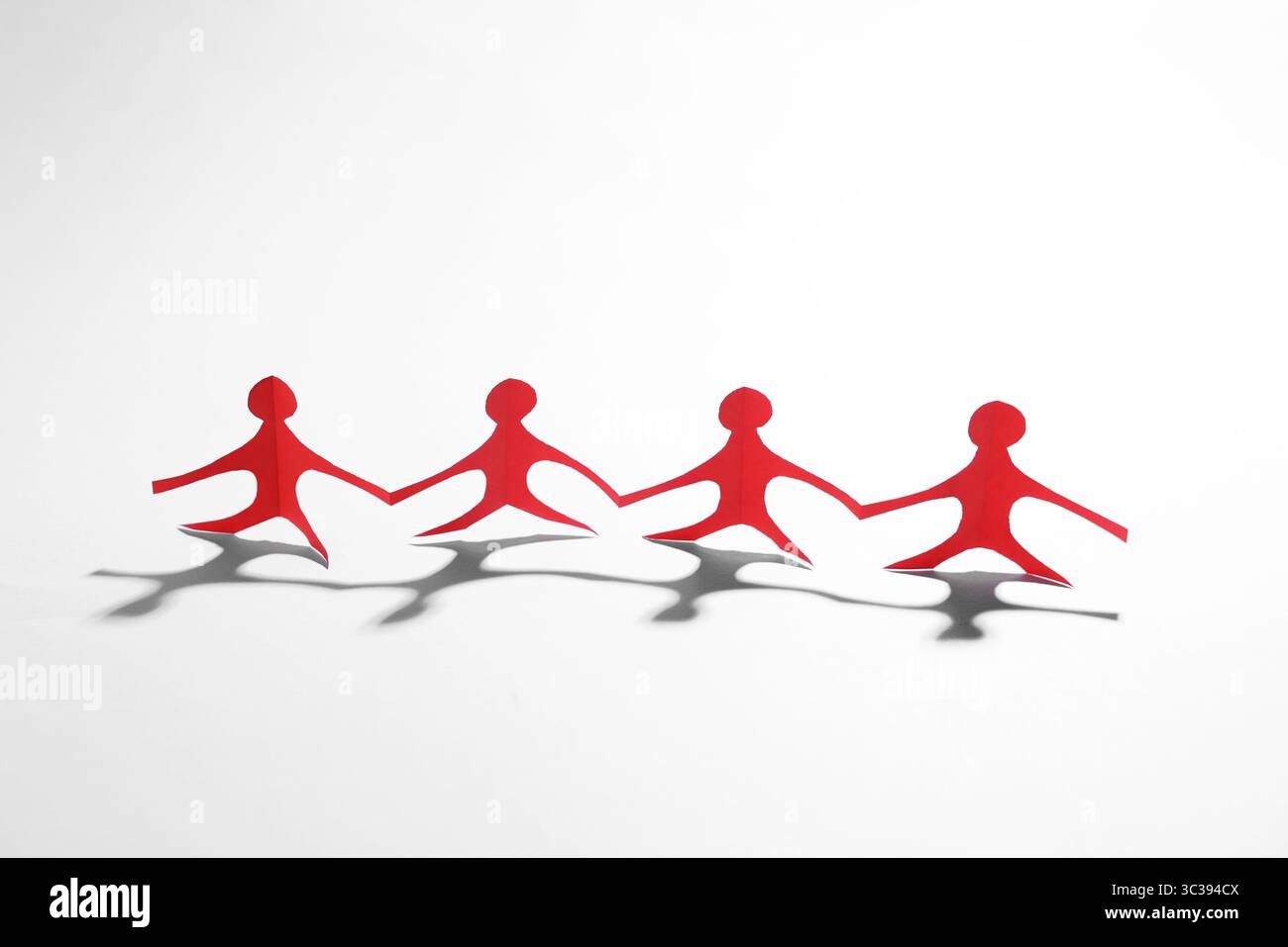 Paper figures of people holding hands on white background Stock Photo ...