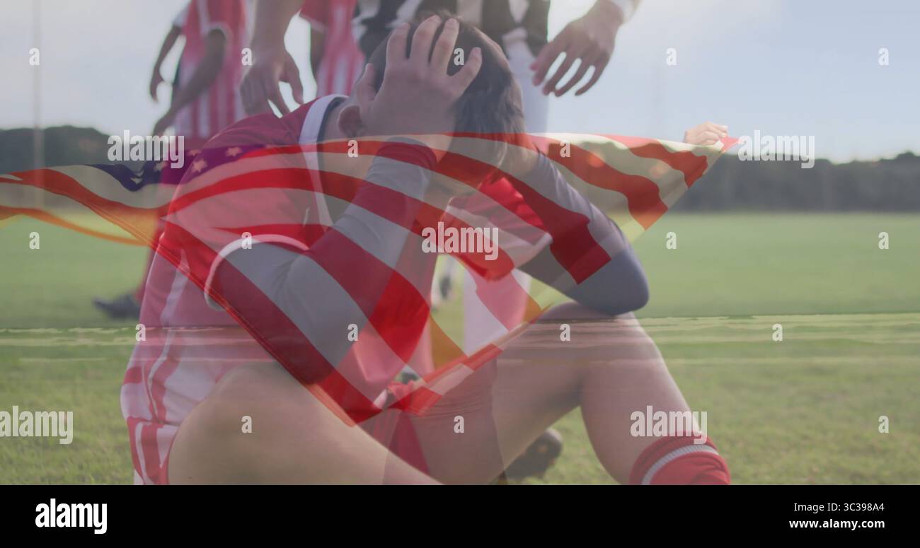 Sad soccer player sitting in striped kit on field holding head, team ...