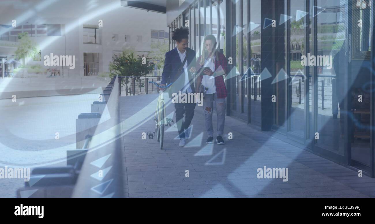 Walking suited and casual colleagues reviewing tablet at office plaza ...