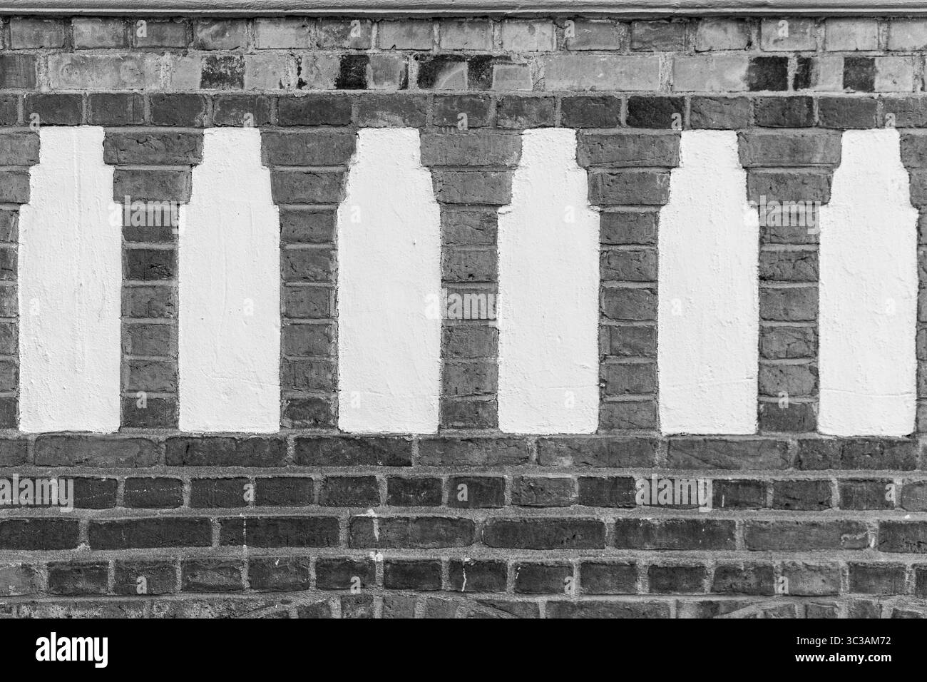 An architectural photograph showing a sequence of white plaster columns ...