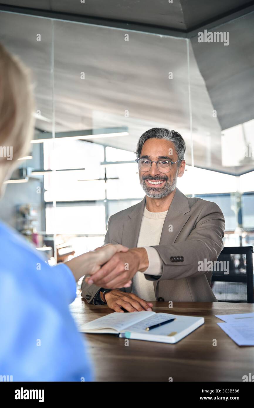 Happy middle aged business man hiring recruit at job interview ...
