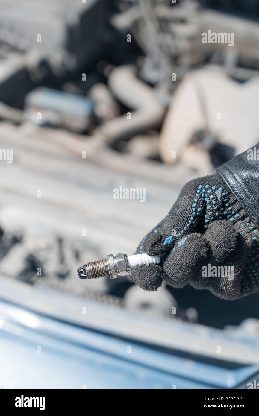 Caucasian man changing spark plugs in car Stock Photo - Alamy