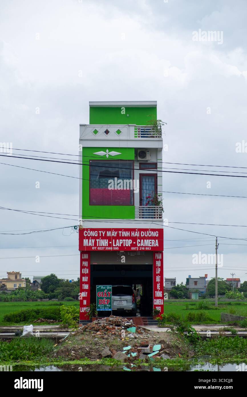 Tall and narrow green building serving as a shop and home in Vietnam ...