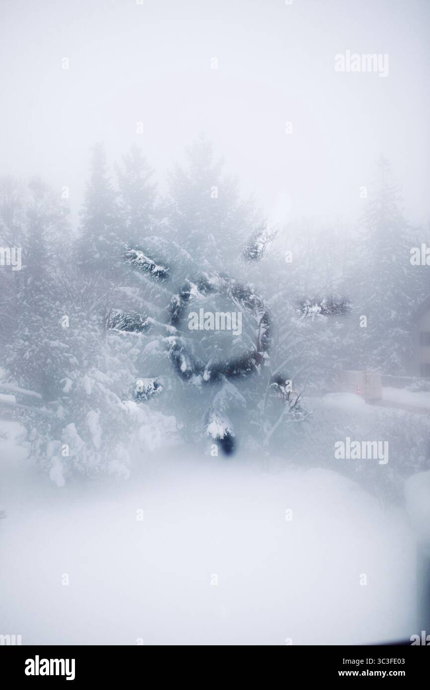 A sun shape is drawn on a foggy window, partially revealing the view of ...