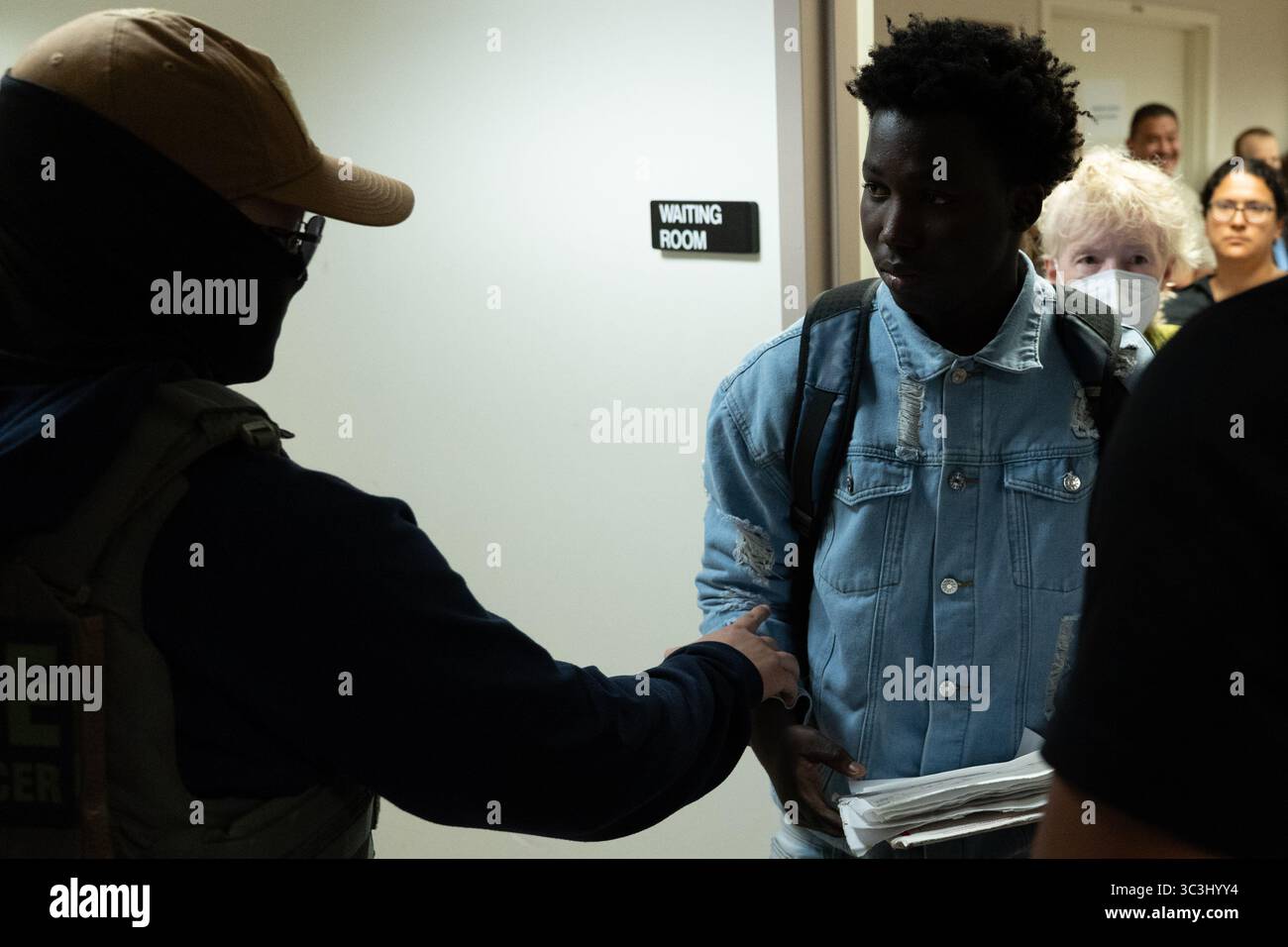 A young man is stopped and detained by Federal agents at the Executive ...