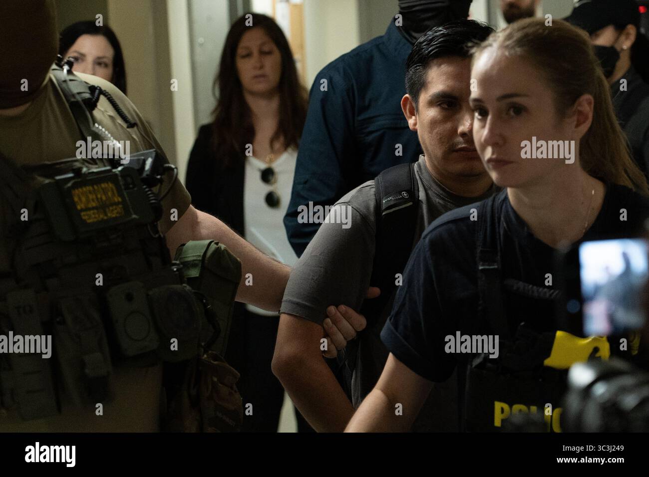 A man is detained and escorted by Border Patrol agents at the Executive ...