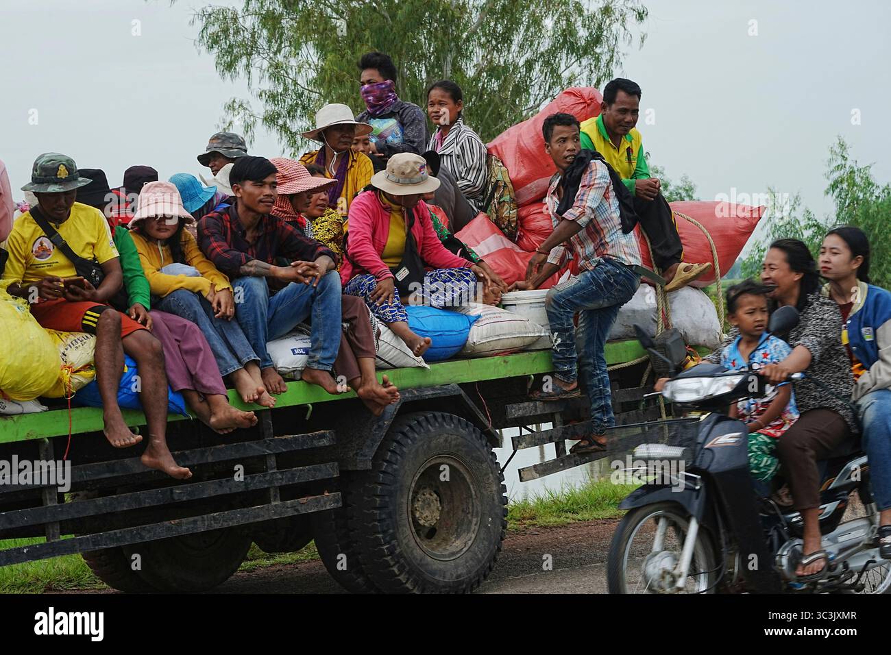 Cambodians sit on a cart of a tractor as they take refuge in Oddar ...