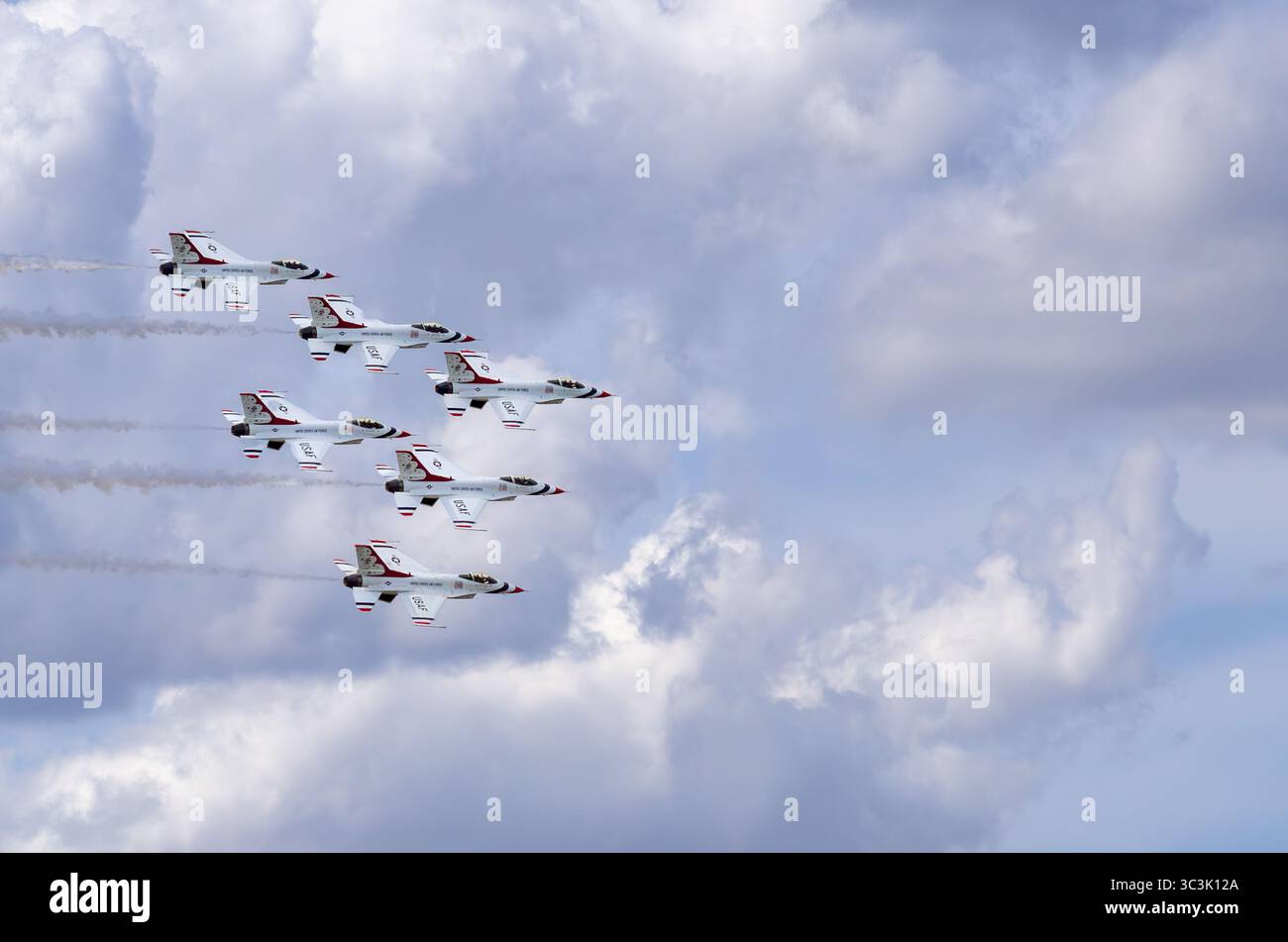 Six USAF Thunderbirds fly in a slightly banked horizontal formation ...