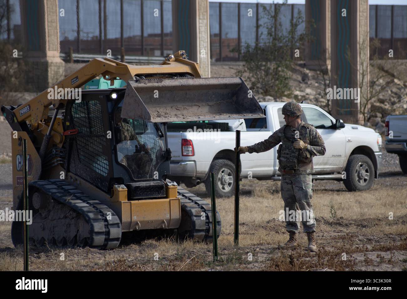 Military personnel manage heavy machinery by a border fence near Ciudad ...