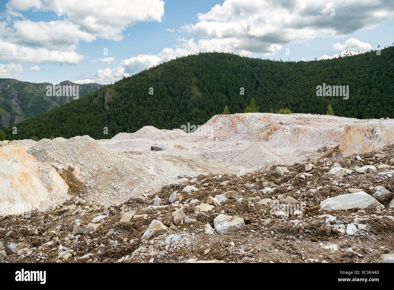Open pit marble quarry with large piles of crushed rock and visible raw stone, showcasing mining ...