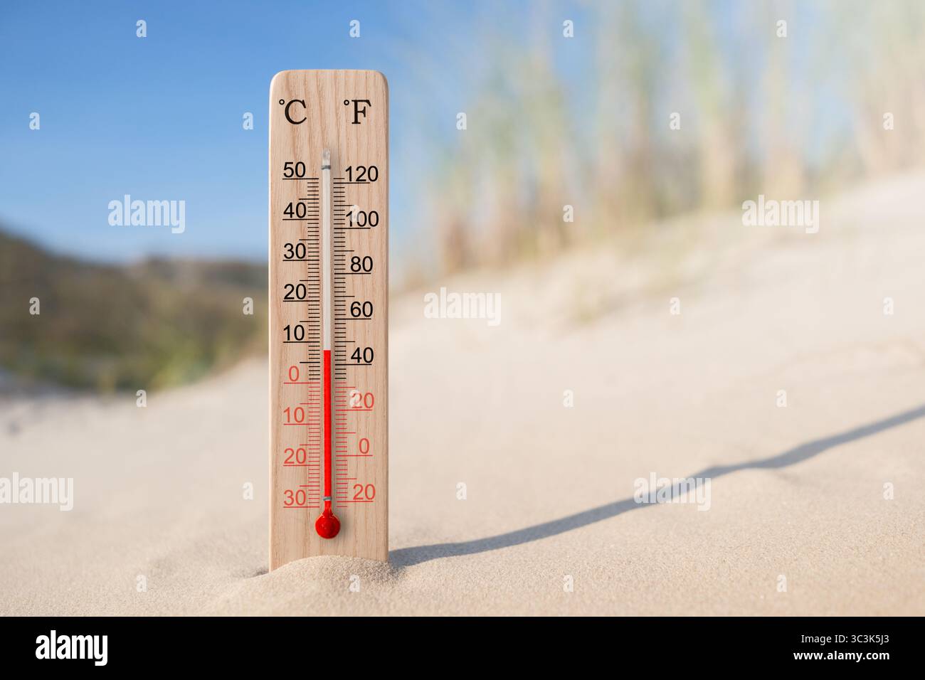 Wooden celsius and fahrenheit scale thermometer in the sand. Ambient ...