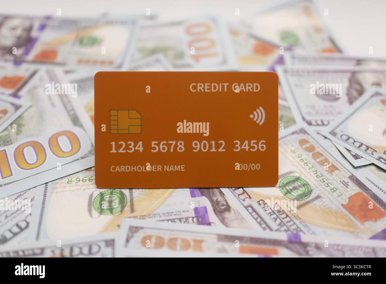 Orange Credit Card on Spread of US Bills Stock Photo - Alamy