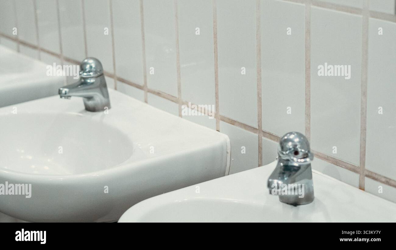 Hygienic white restroom interior with multiple sinks for hand washing ...
