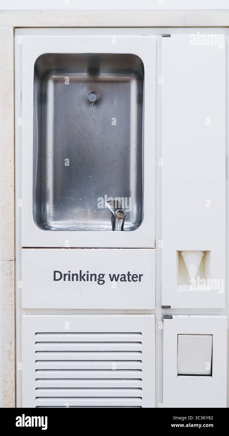 Vintage water dispenser machine standing inside an old public building ...