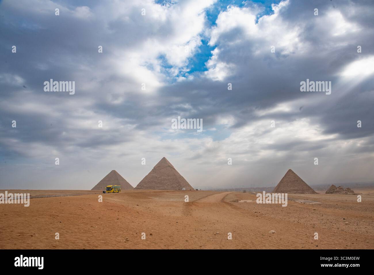 A tourist bus passes near the Great Pyramids of Giza, viewed from the ...