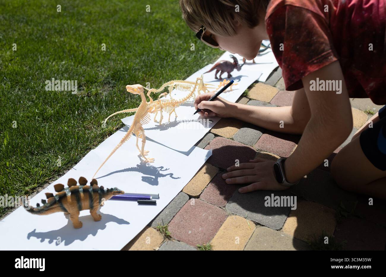 child tracing outline contrasting shadows from different figures of toy ...
