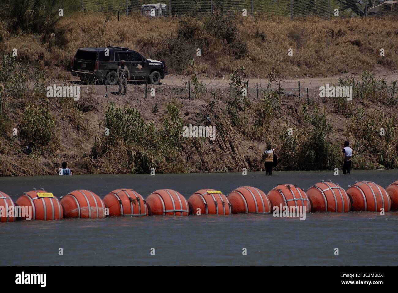 Armed security guards oversee a river with barriers in Ciudad Juarez, a ...