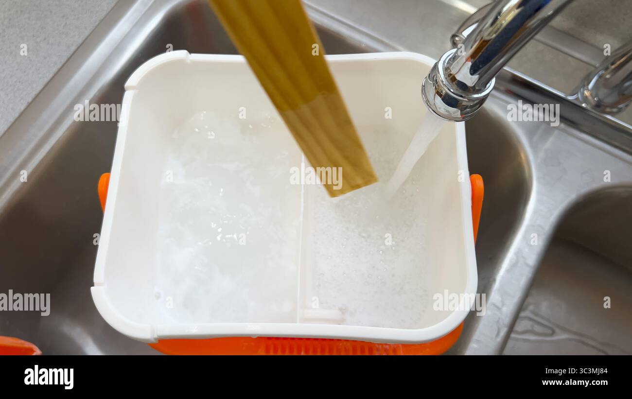 Filling bucket with soap and water for mopping Stock Photo - Alamy