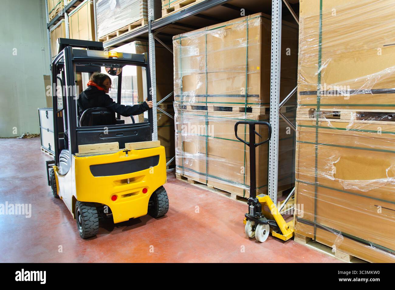 A woman expertly maneuvers a forklift in a solar panel warehouse ...