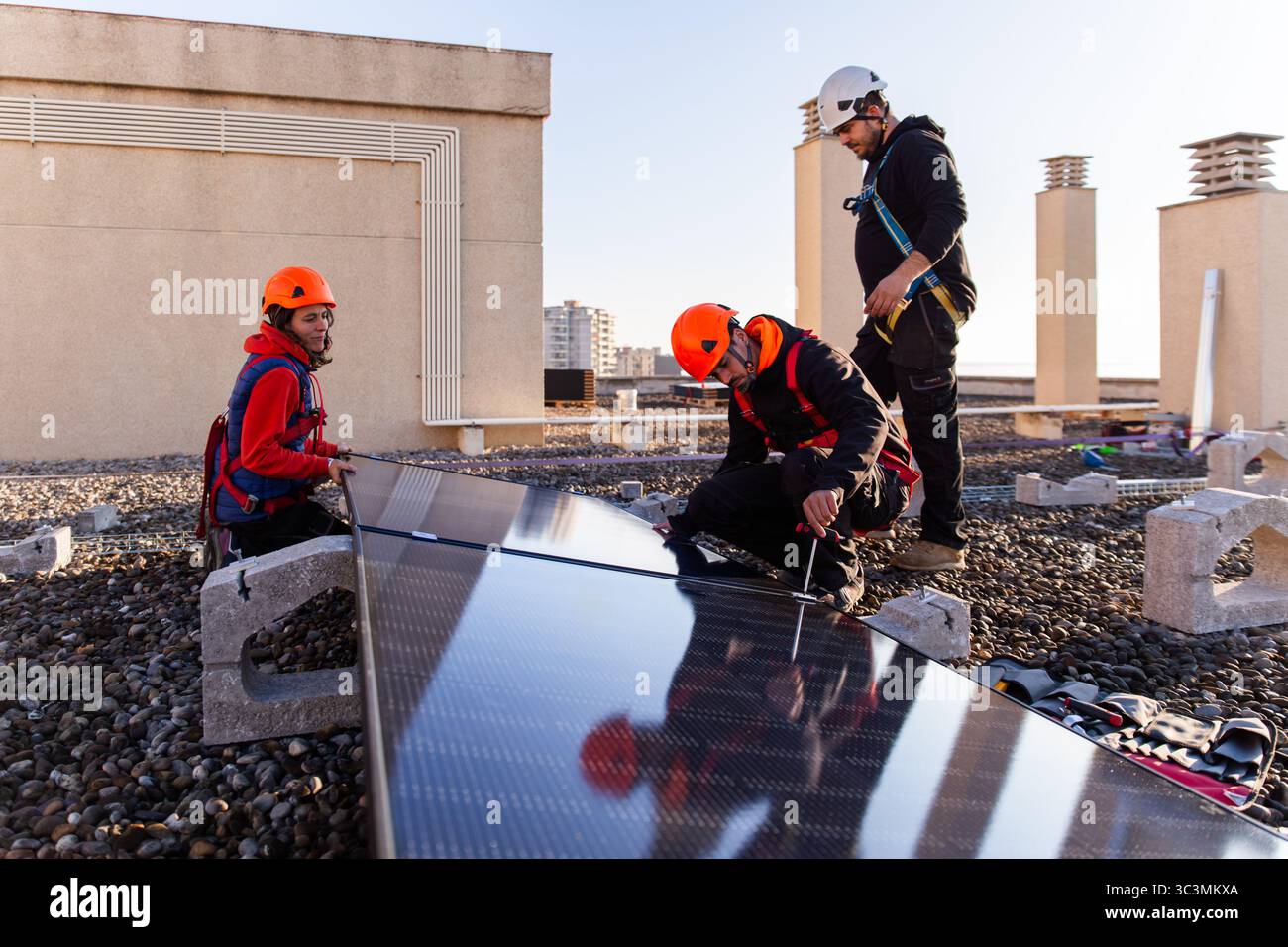 Professional team installing solar panels on a flat rooftop in an urban ...