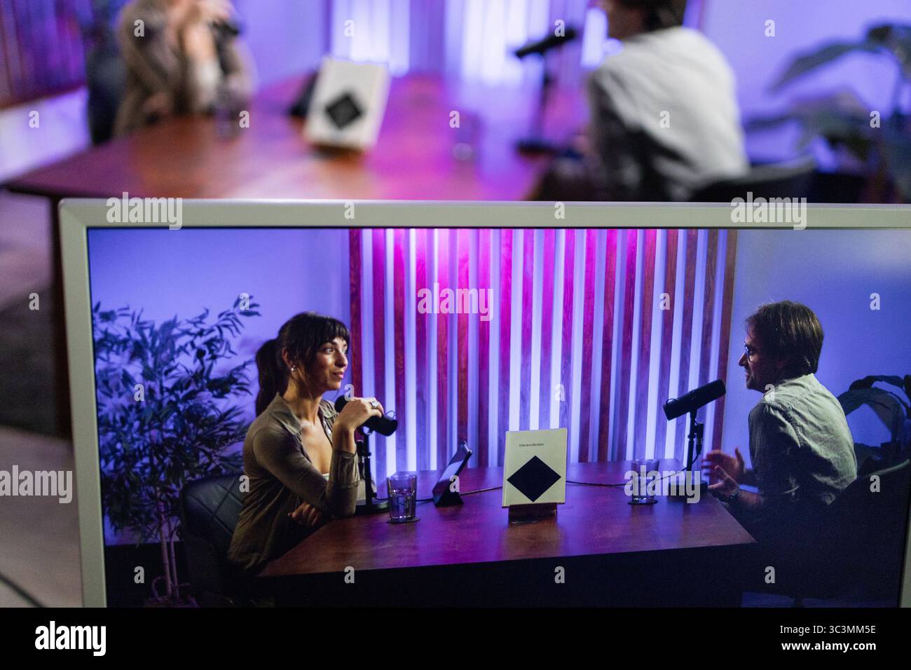 Cozy podcast recording studio featuring a dynamic interview setup. Two ...