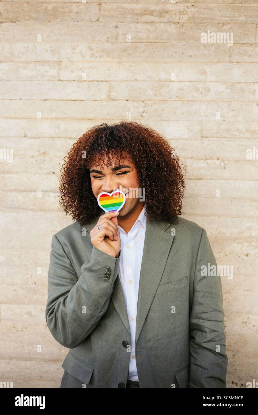 A joyful trans woman stands outdoors, smiling confidently while holding ...