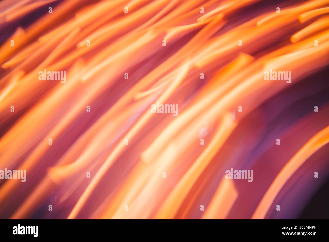 This abstract image captures the dynamic movement of orange light ...