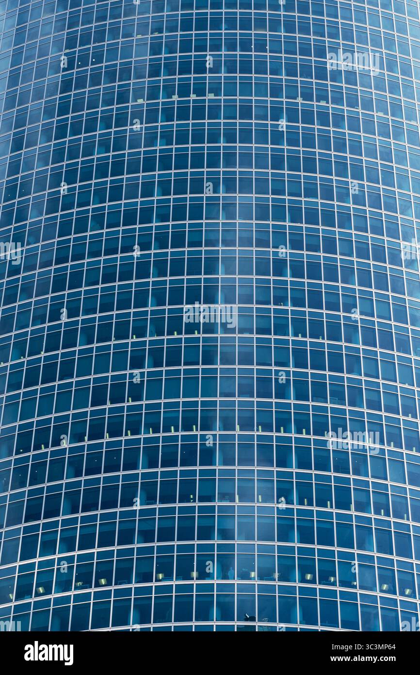 A modern skyscraper featuring a curved facade composed of reflective ...