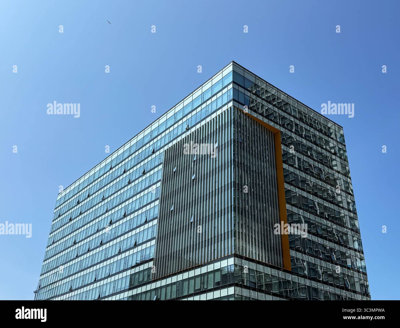 Contemporary skyscraper with a sleek glass facade reflecting the clear ...